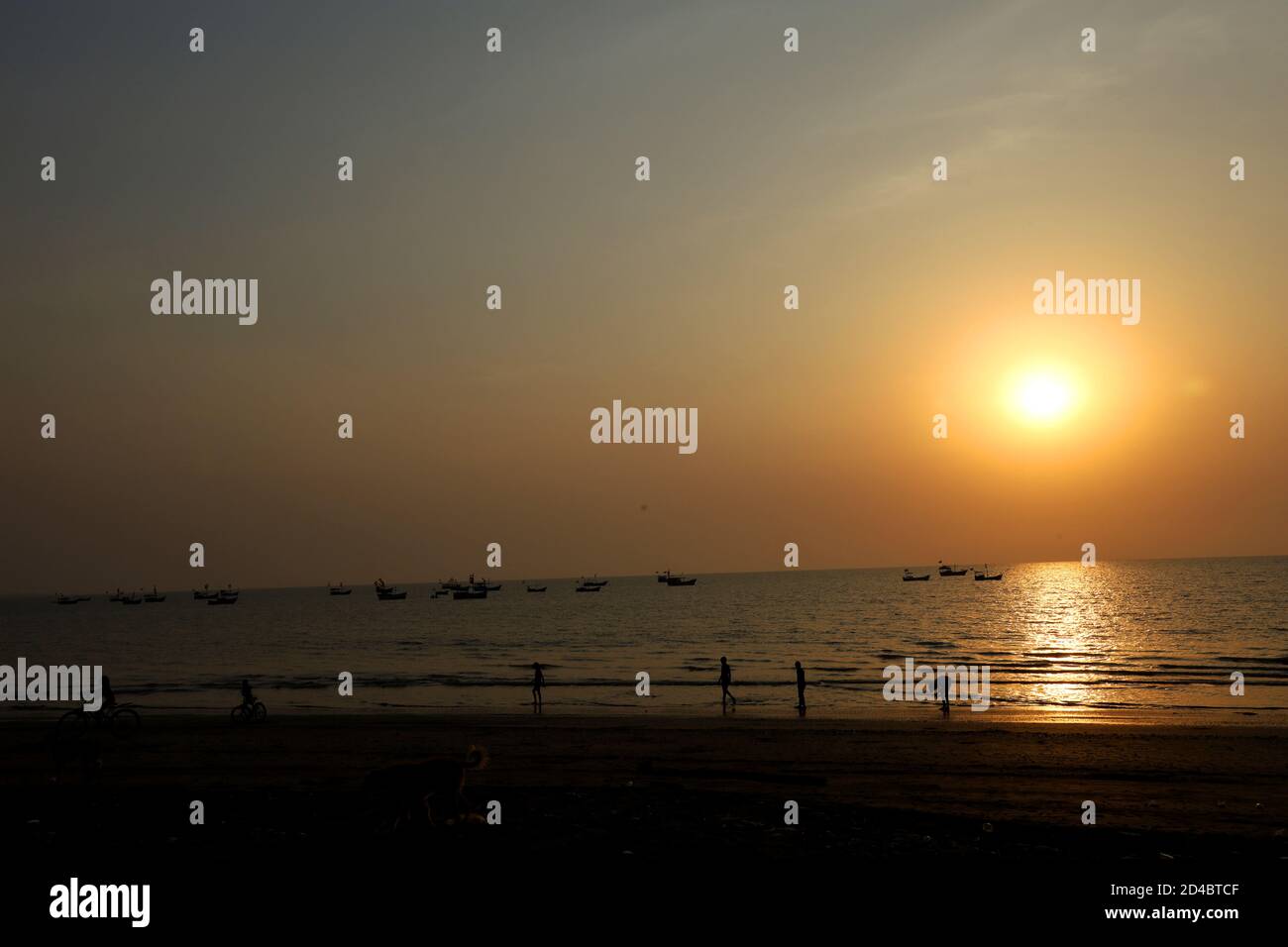 The sunset at a lovely beach crowded by peoples Stock Photo - Alamy