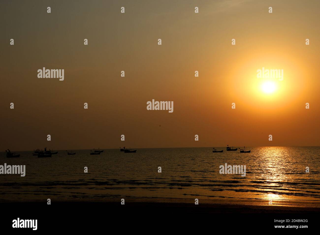The sunset at a lovely beach crowded by peoples Stock Photo - Alamy
