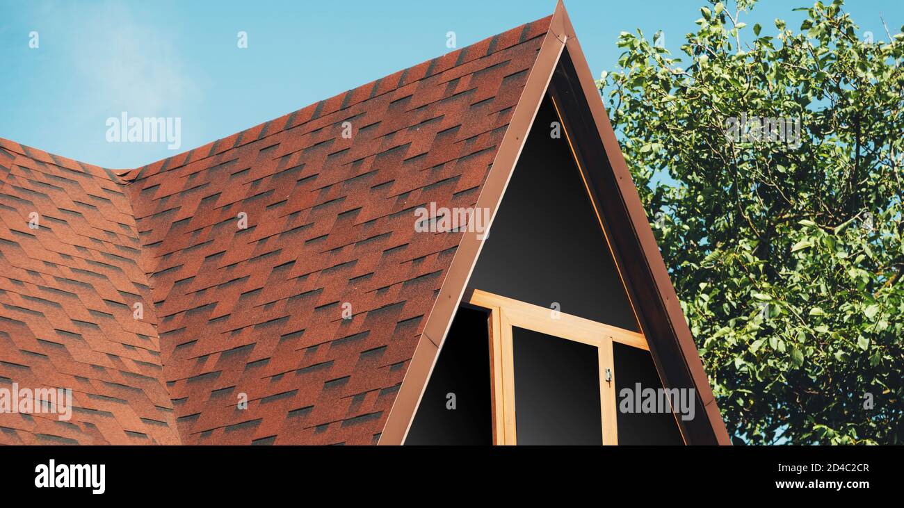 A brown modern house roof near a tree Stock Photo - Alamy