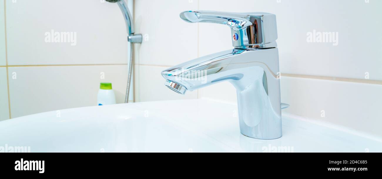 chromed metal faucet for hot and cold water, cup with sad face for ...