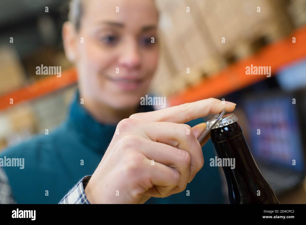 female worker opening a beer bottle with a bottle opener Stock Photo ...