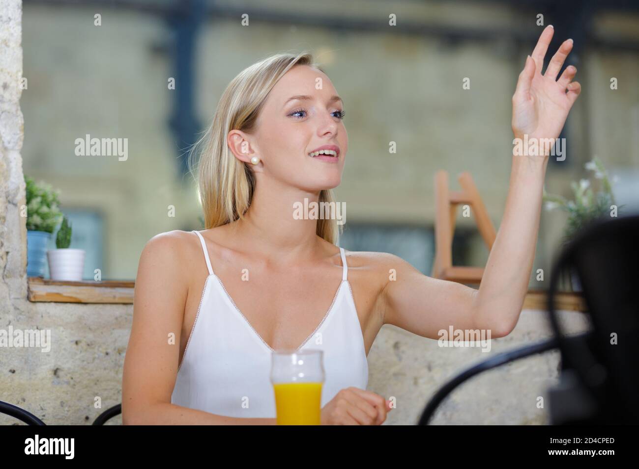 elegant woman calling for waiter Stock Photo - Alamy