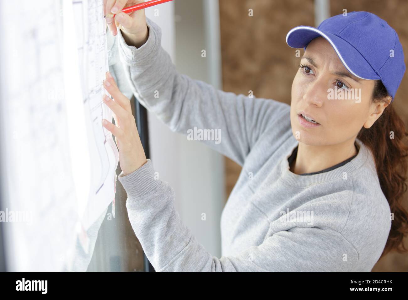 midsection of female architect with blueprint at site Stock Photo - Alamy