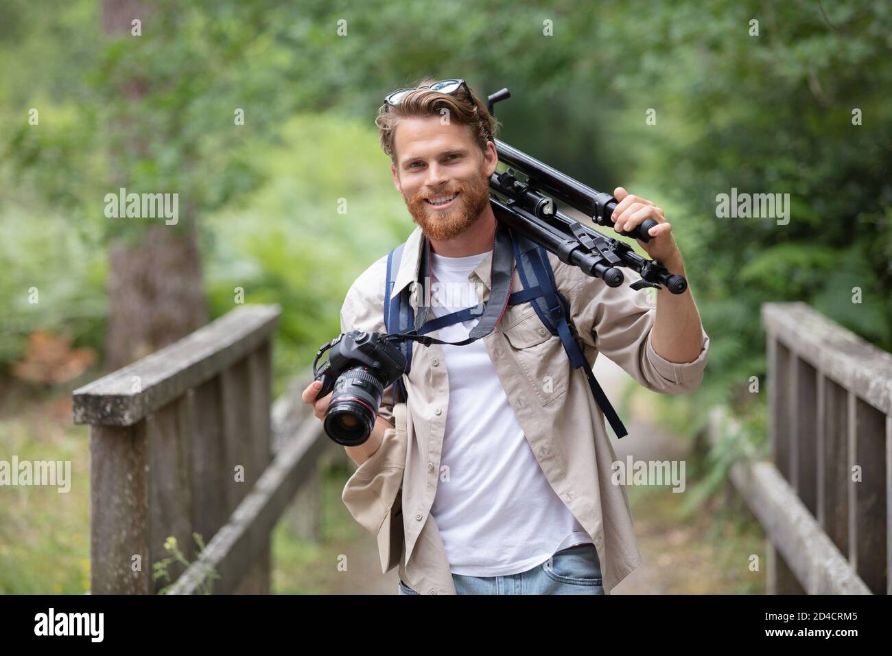 happy male photographer carrying the tripod Stock Photo - Alamy