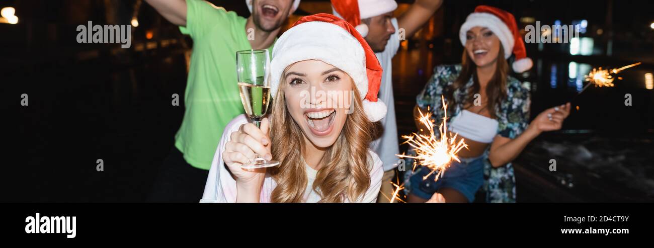 Horizontal image of excited woman holding glass of champagne and ...