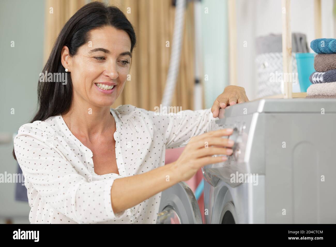 woman loading clothes into washing machine Stock Photo - Alamy