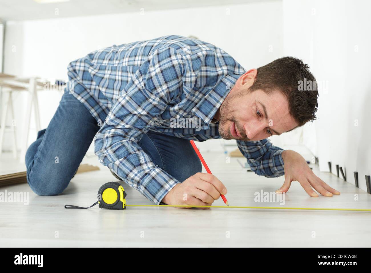 man measuring a flooring board Stock Photo - Alamy