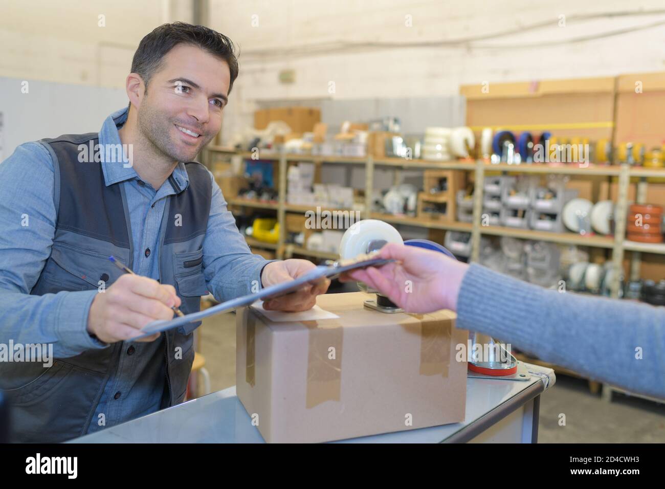 man signing for the delivery of boxes Stock Photo - Alamy