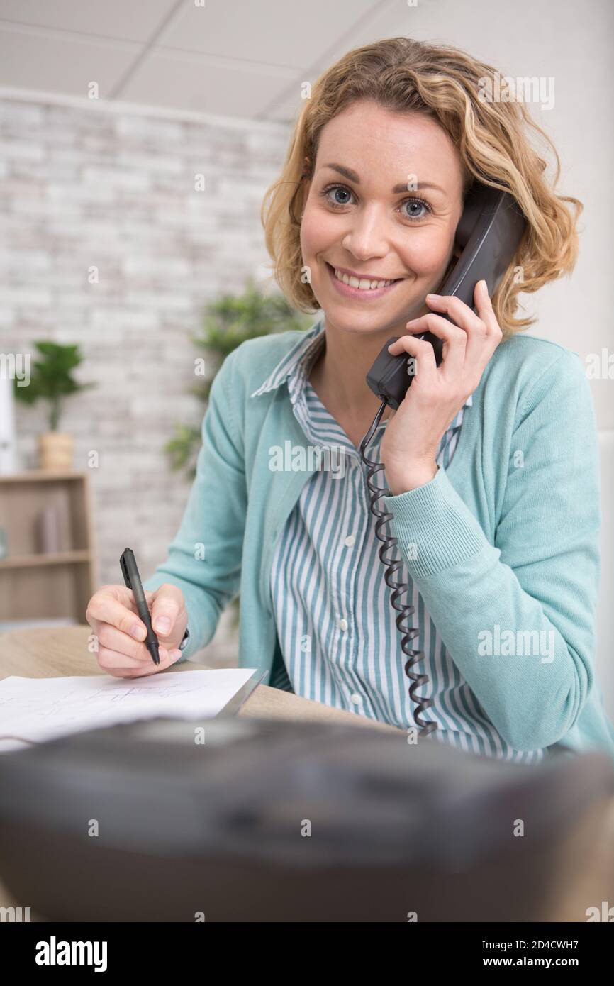 woman sat at desk using telephone switchboard Stock Photo - Alamy