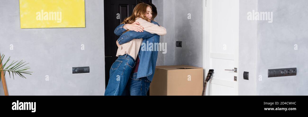 horizontal image of joyful couple hugging in new home Stock Photo - Alamy