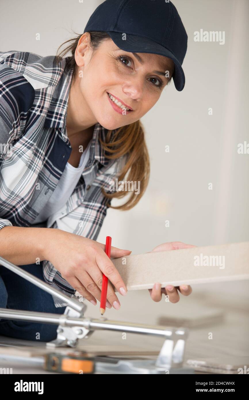 happy woman worker is cutting tiles Stock Photo - Alamy