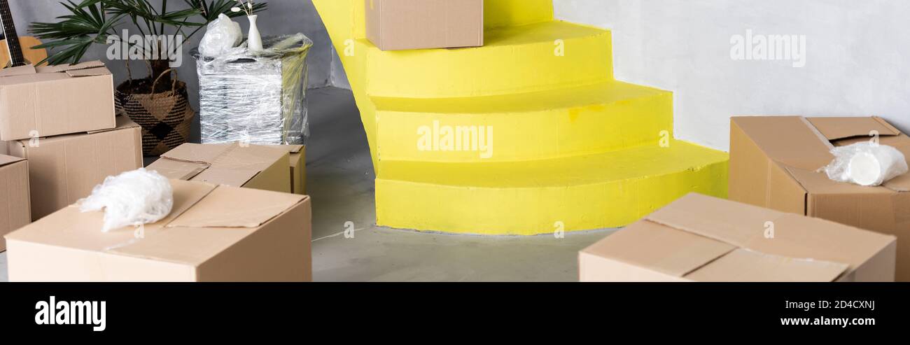 carton boxes on yellow stairs in new apartment, moving concept Stock ...