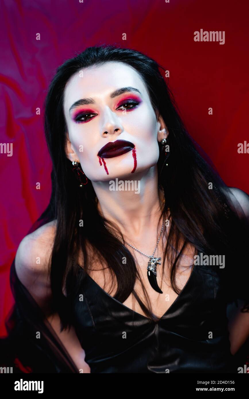 pale woman with blood on face looking at camera on red Stock Photo - Alamy