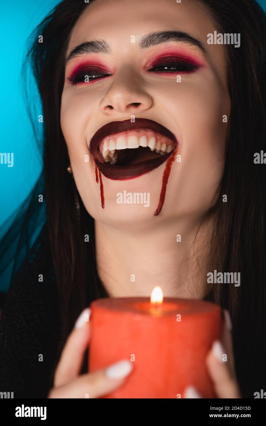 selective focus of brunette woman with blood on face holding burning ...