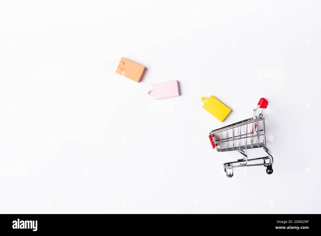 Top view of small shopping bags and cart on white background Stock ...
