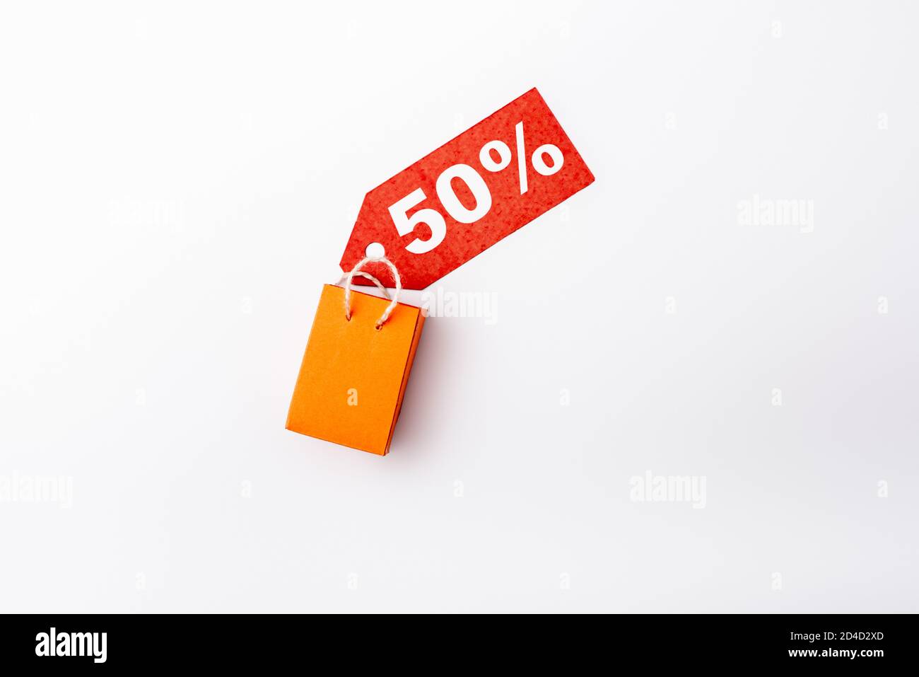 Top view of price tag with 50 percent signs and toy shopping bag on ...