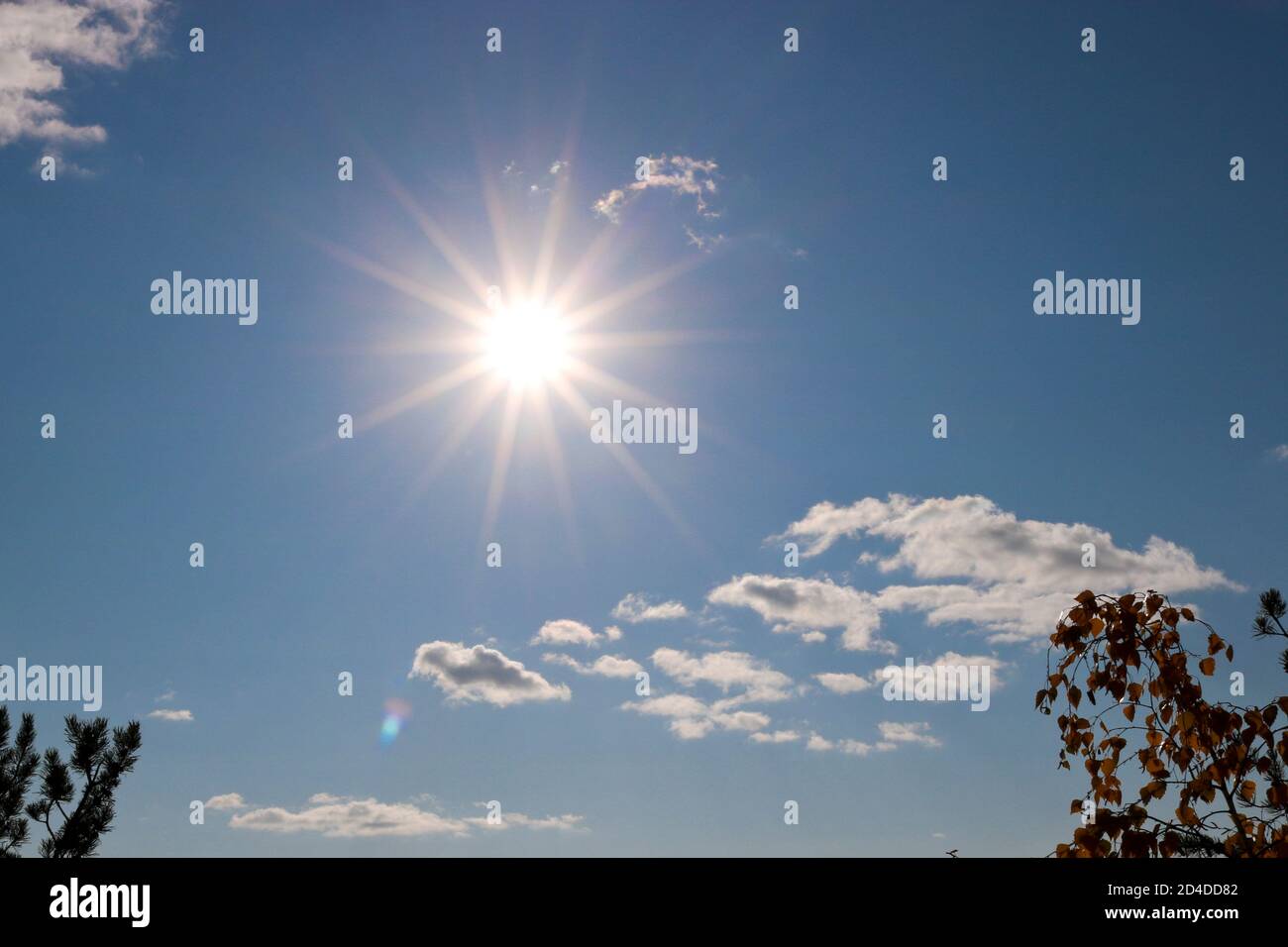 Bright sun with rays on a background of blue sky with clouds. Ready ...