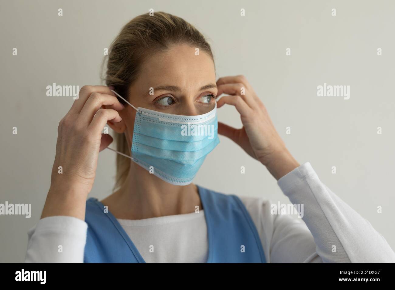 Female health worker wearing face mask against white background Stock ...