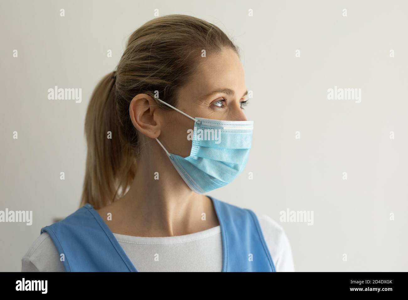 Female health worker wearing face mask against white background Stock ...