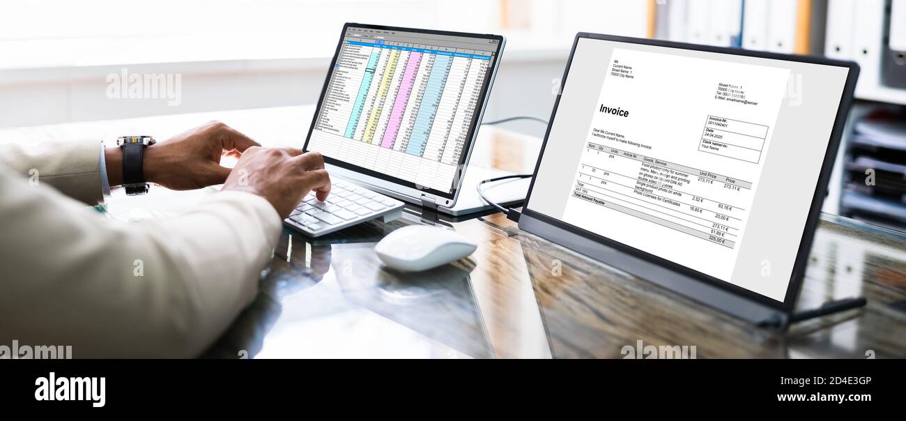 Looking At Invoice And Spreadsheet On Laptop At Work Stock Photo - Alamy