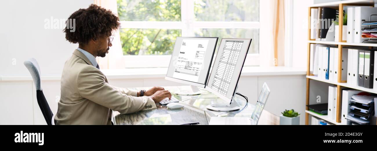 Looking At Invoice And Spreadsheet On Computer At Work Stock Photo - Alamy