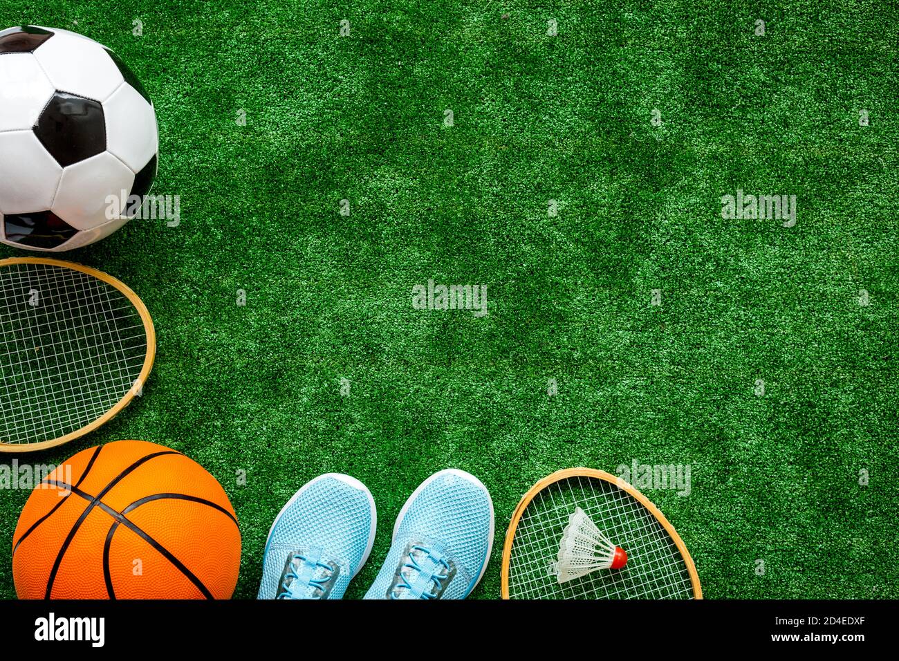 Sport balls and badminton rackets on football grass. Top view copy ...
