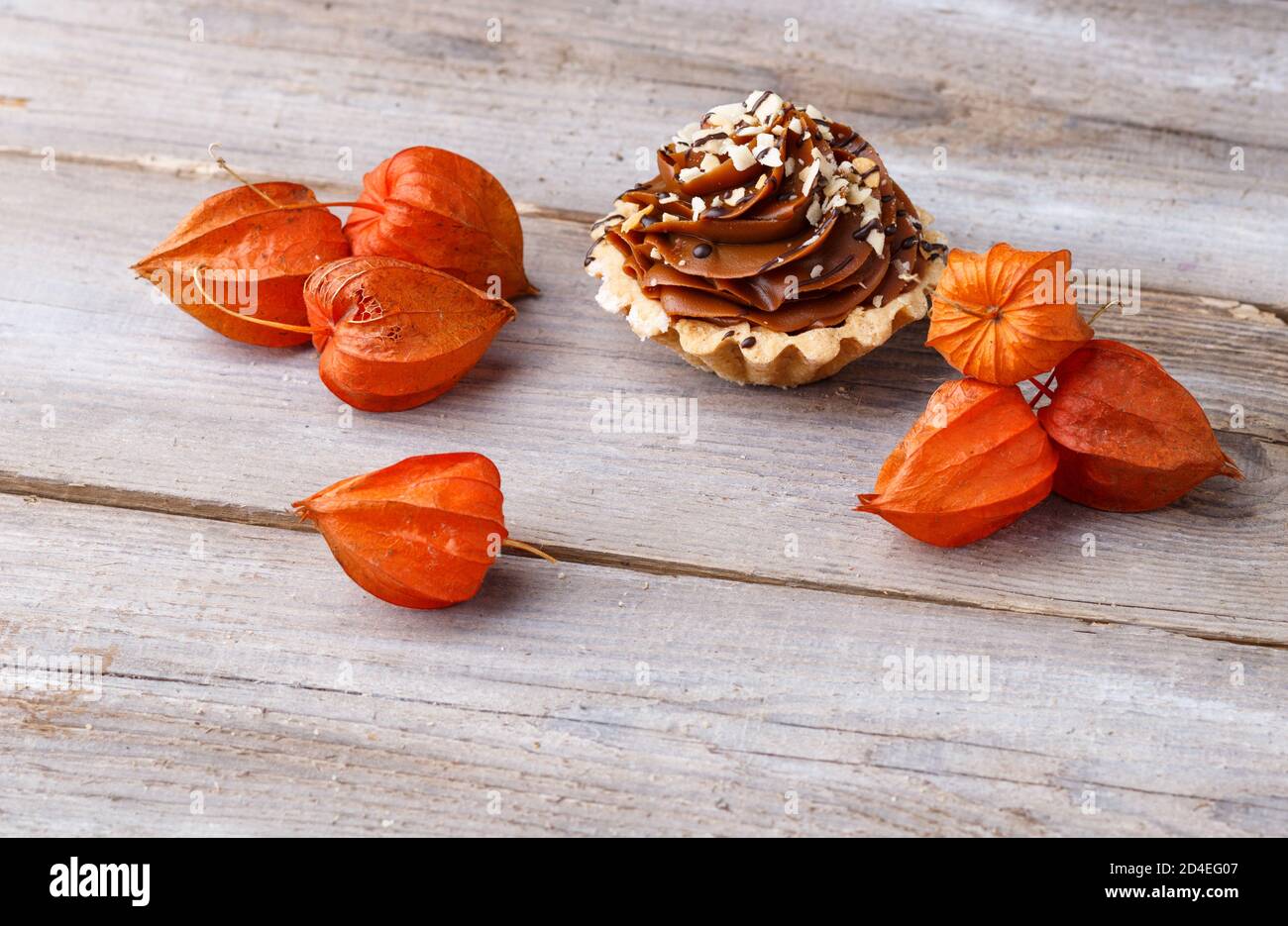 cake with cream and red physalis on a rustic wooden background Stock ...