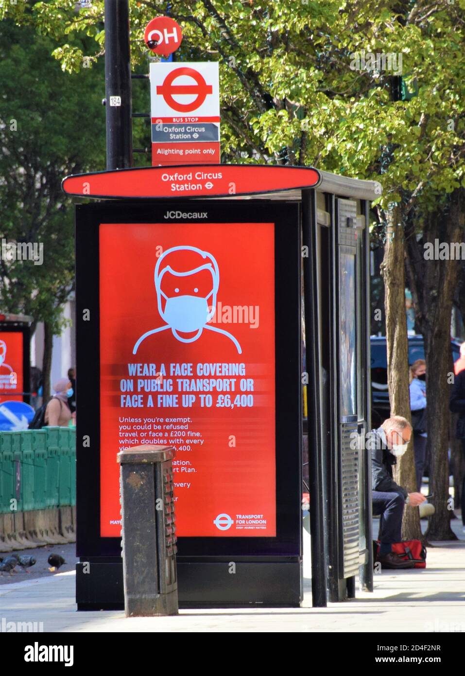 Wear A Face Covering sign at a bus stop on Oxford Street, London Stock ...