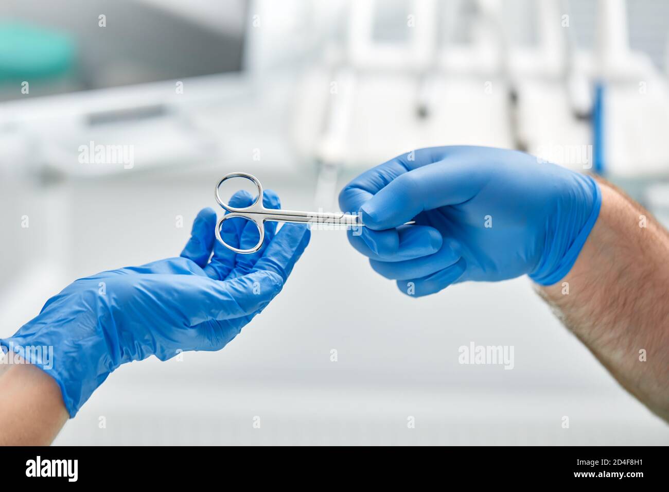 Close-up of the hands of a dentist and nurse surgeon over an operating ...