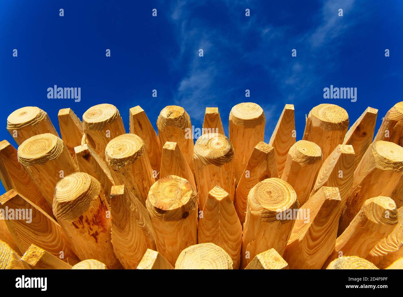 A stack of freshly made wooden posts against a blue sky. You can use a ...