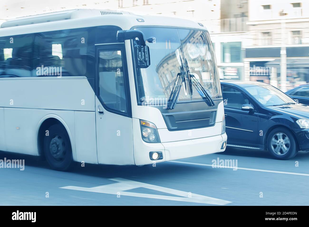 white tourist bus goes on the city street Stock Photo - Alamy