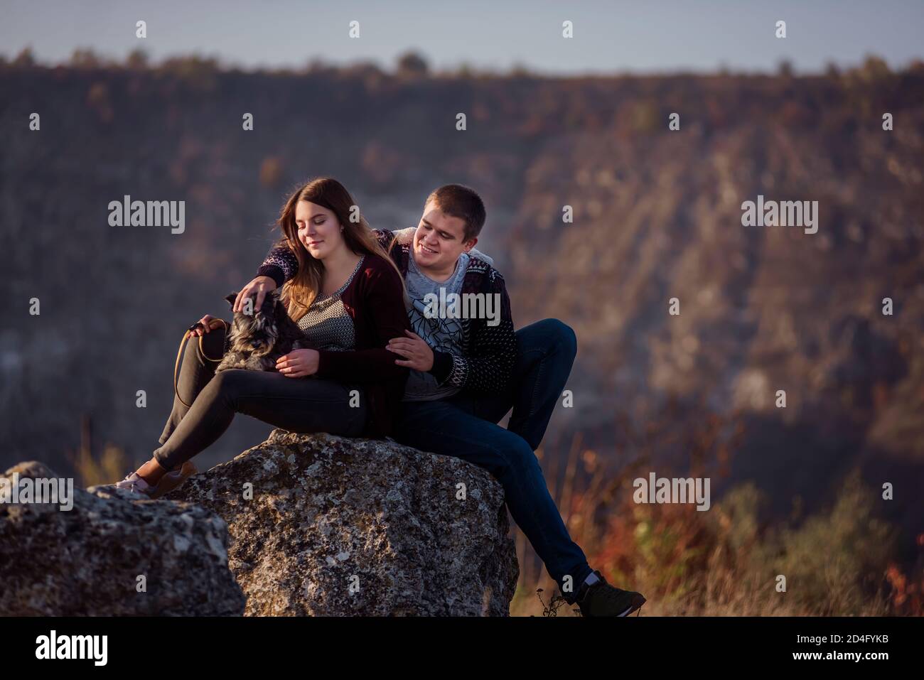 Young family with a schnauzer dog travel. Beautiful Girl hugs a young ...