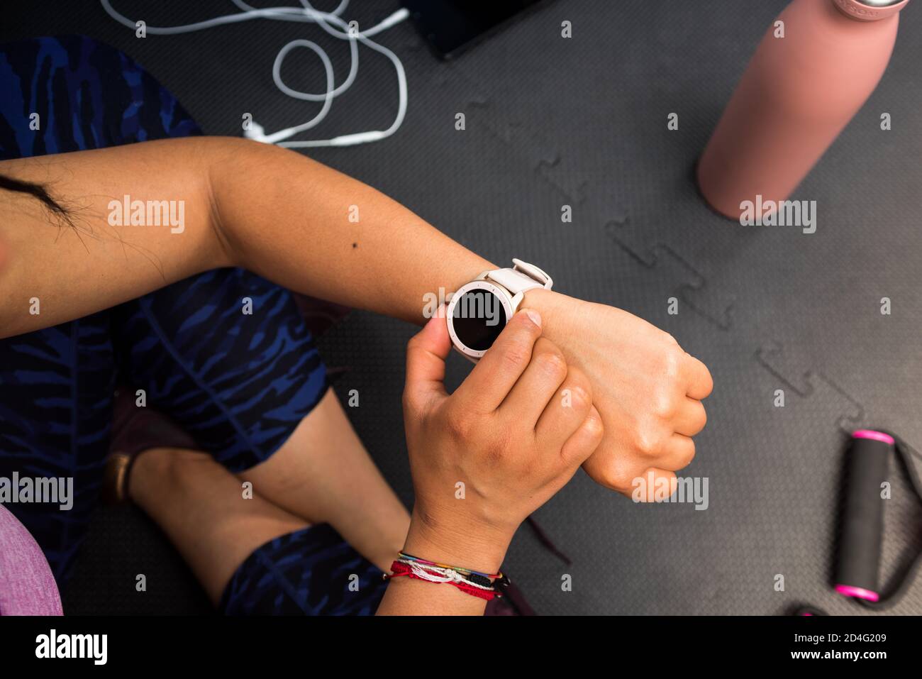 Closeup shot of a woman looking at her smartwatch during doing ...