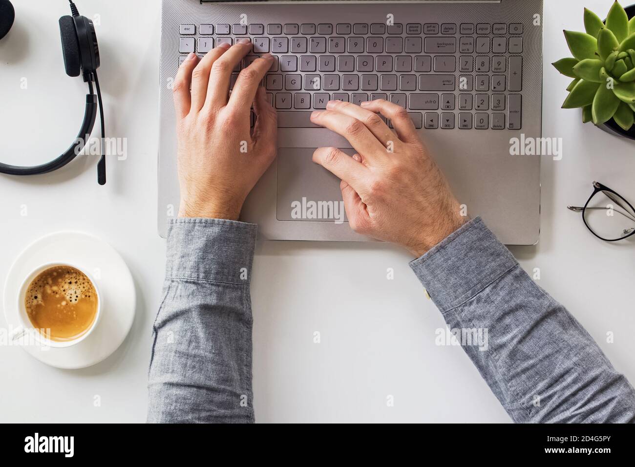 Man working on laptop his workplace. Going to write in notepad ...