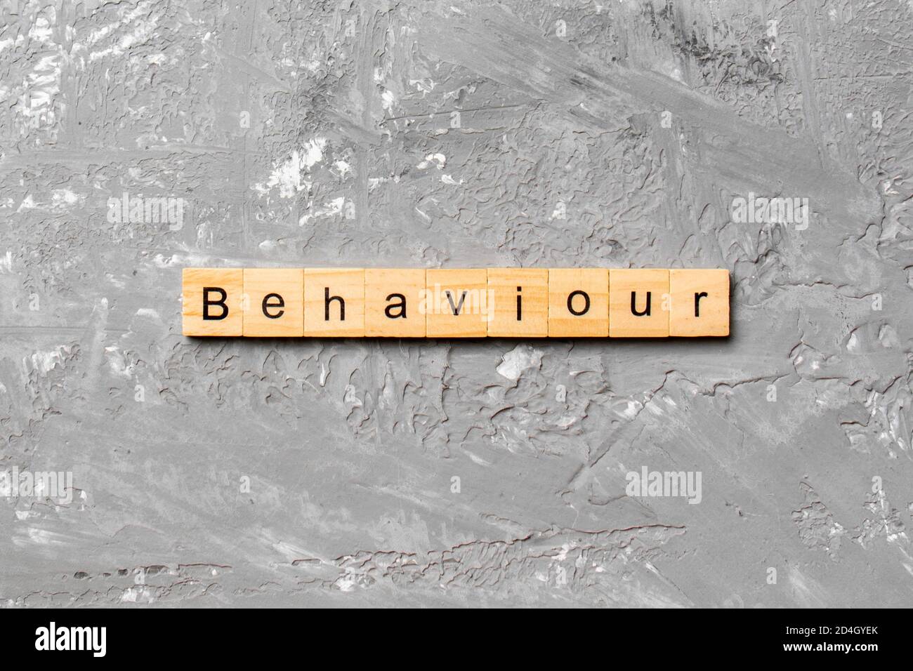 BEHAVIOUR word written on wood block. BEHAVIOUR text on cement table ...