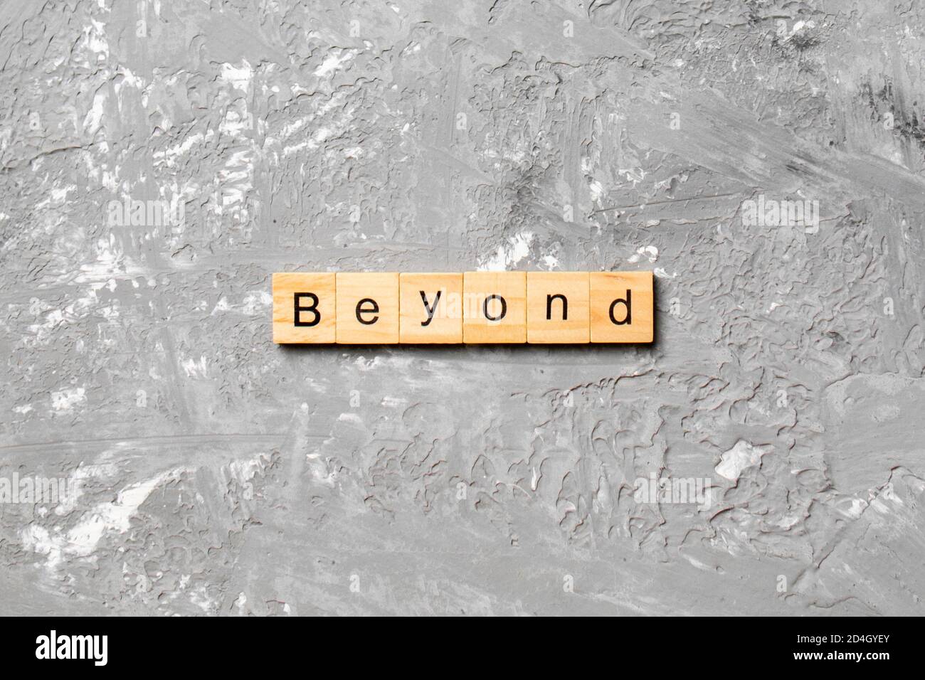 BEYOND word written on wood block. BEYOND text on cement table for your ...