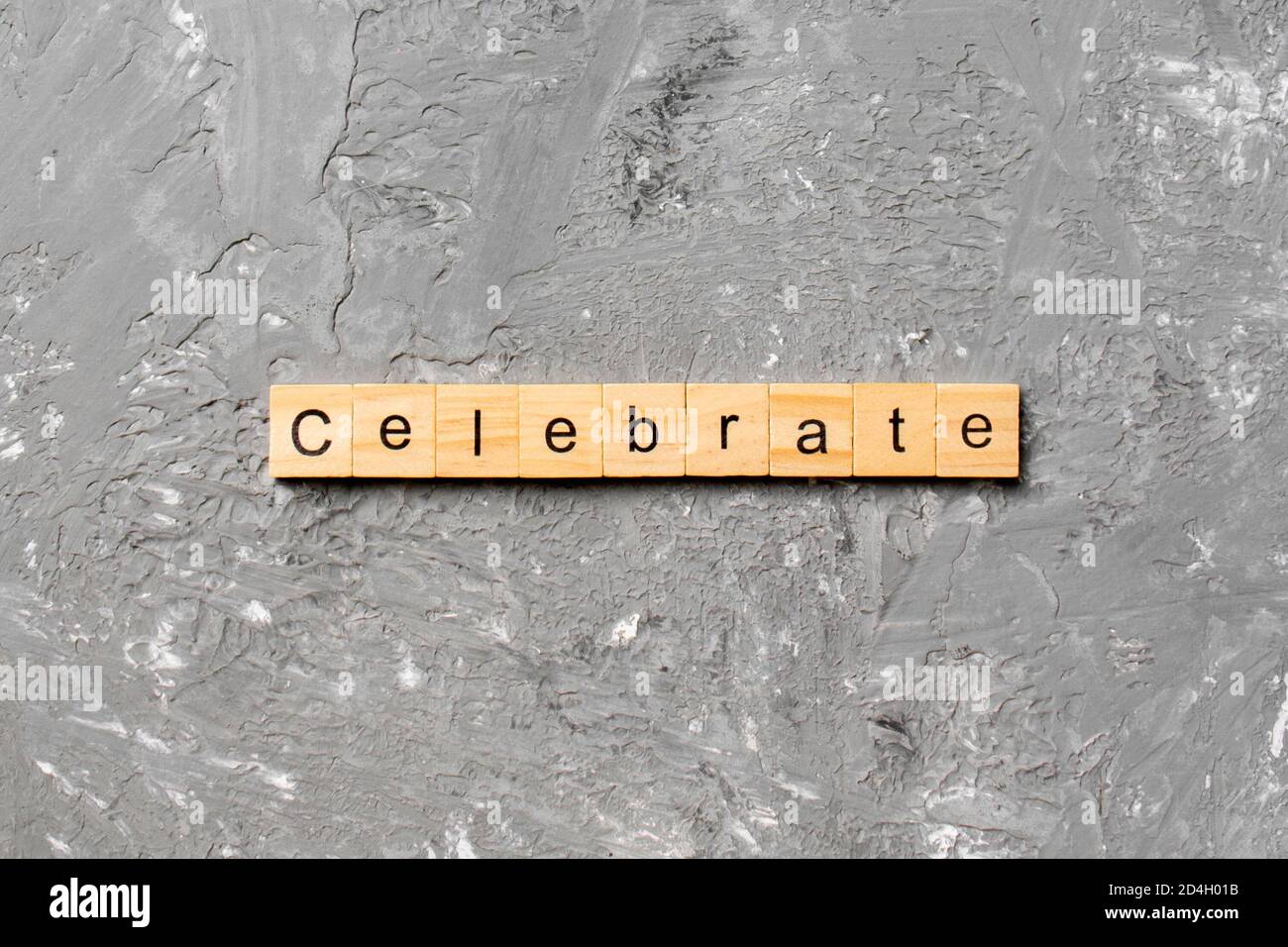 Celebrate word written on wood block. Celebrate text on cement table ...