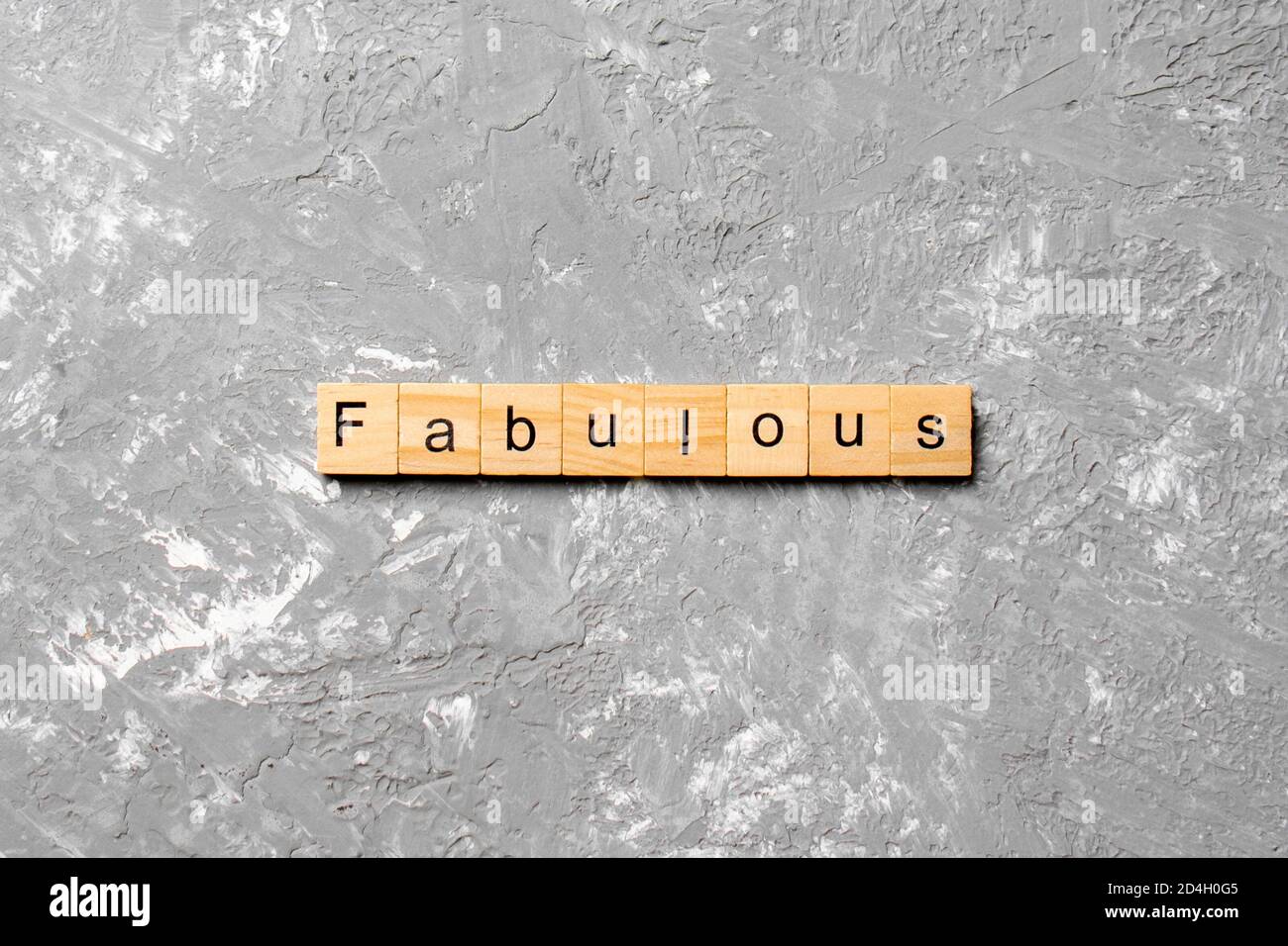 Fabulous word written on wood block. Fabulous text on cement table for ...