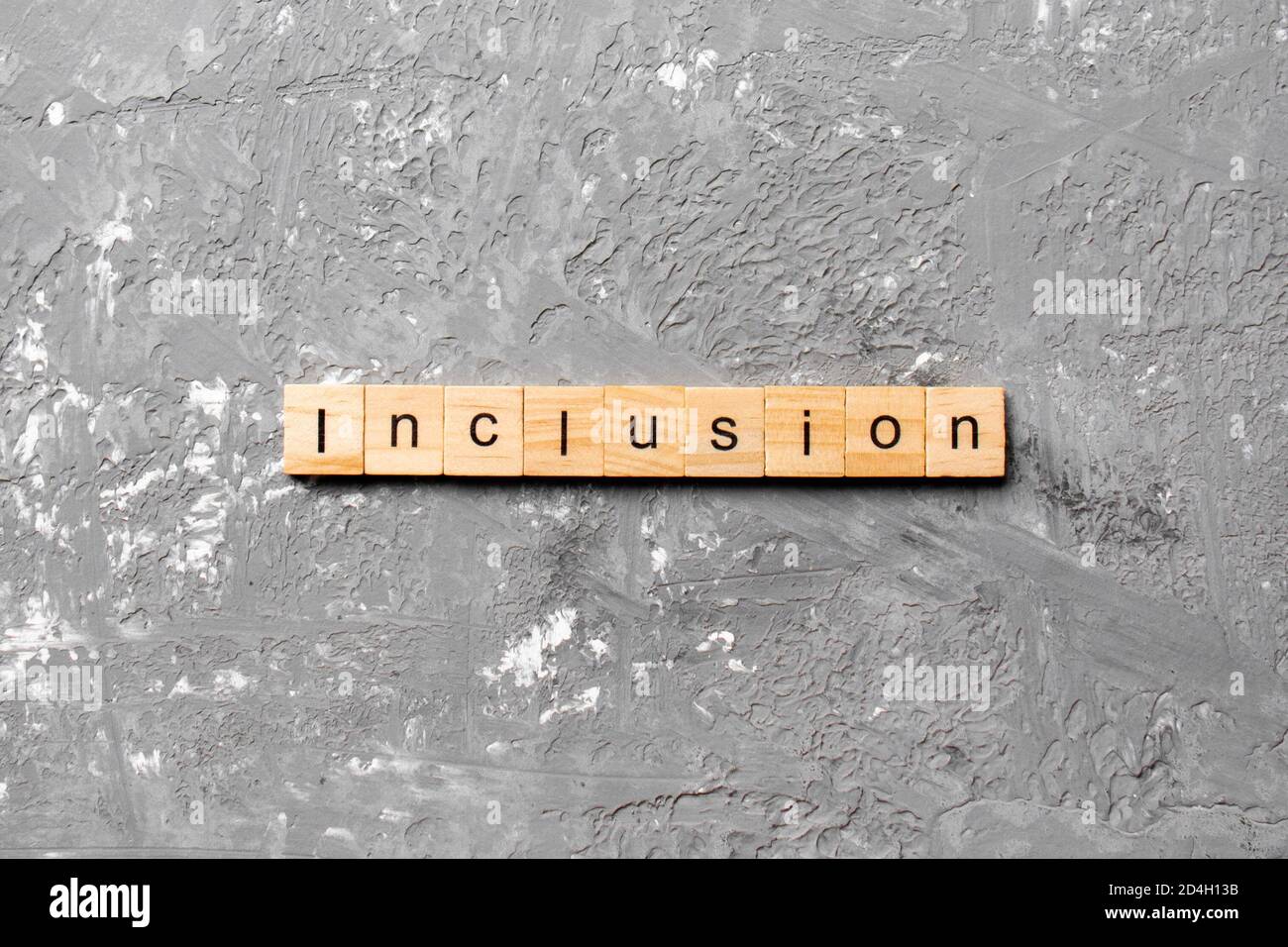 Inclusion word written on wood block. Inclusion text on cement table ...