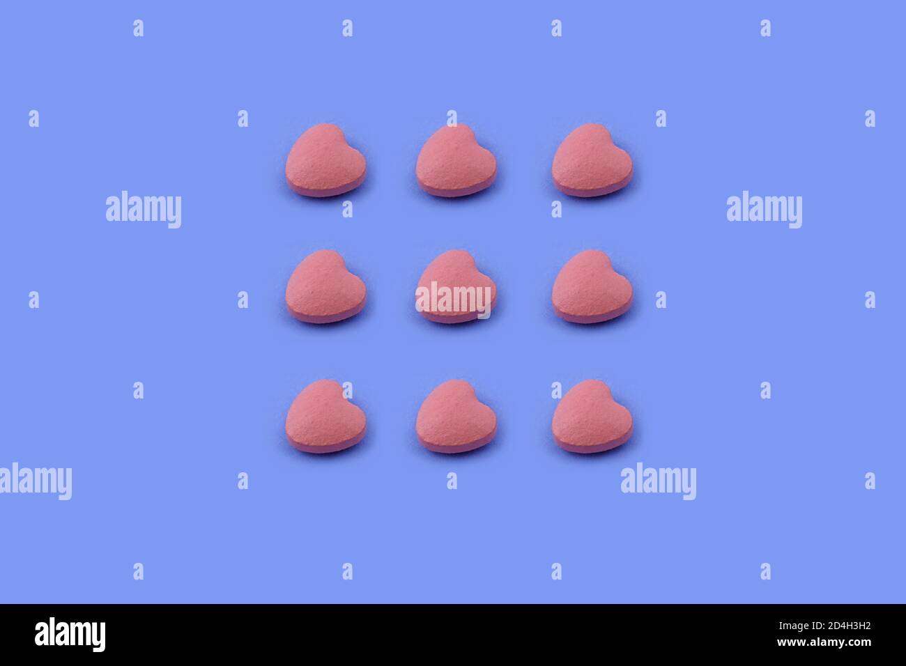 Heart shape Pharmaceutical medicine tablet on a blue background ...