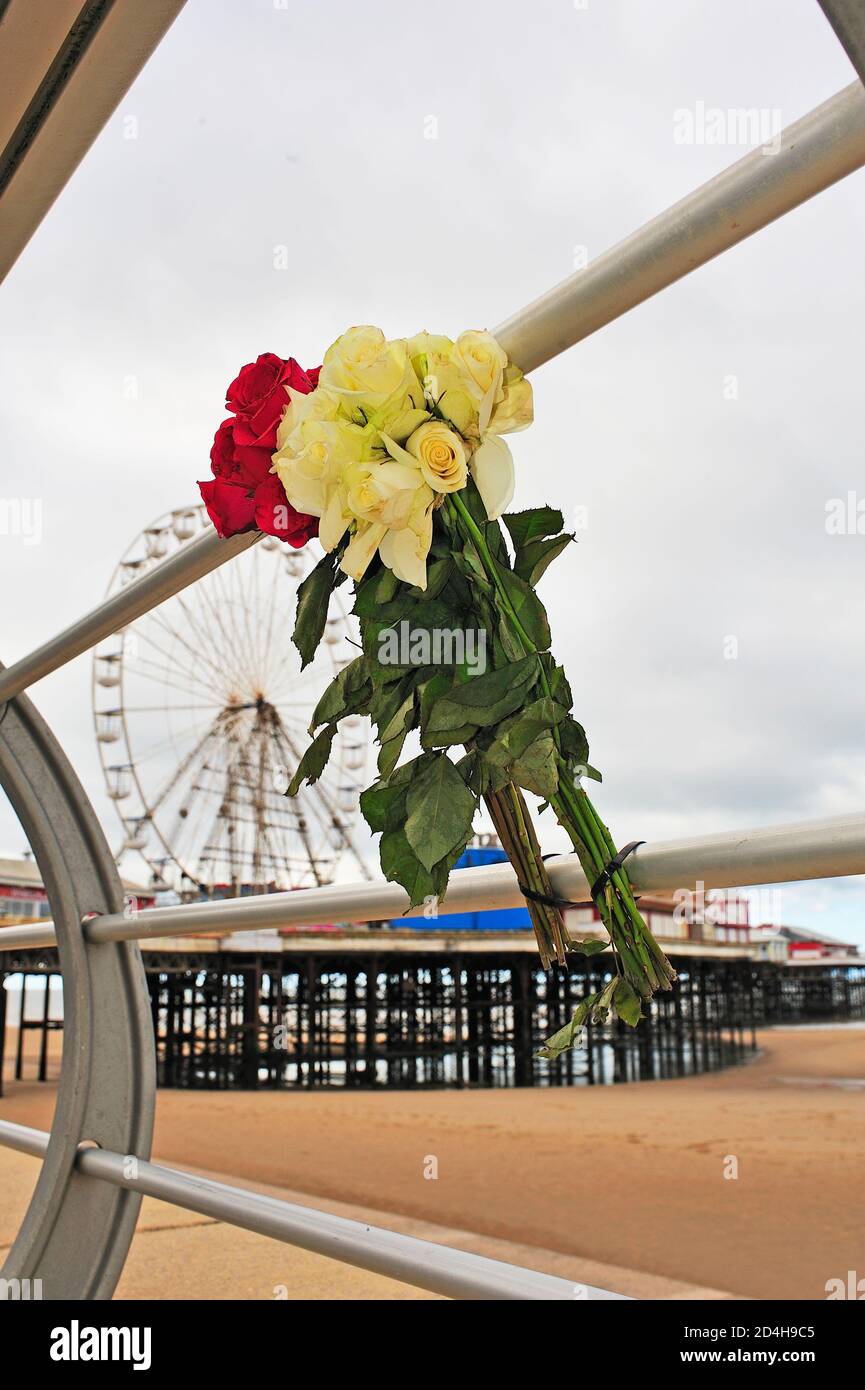 Commemorative roses tied to the railings in front of the Ferris wheel ...