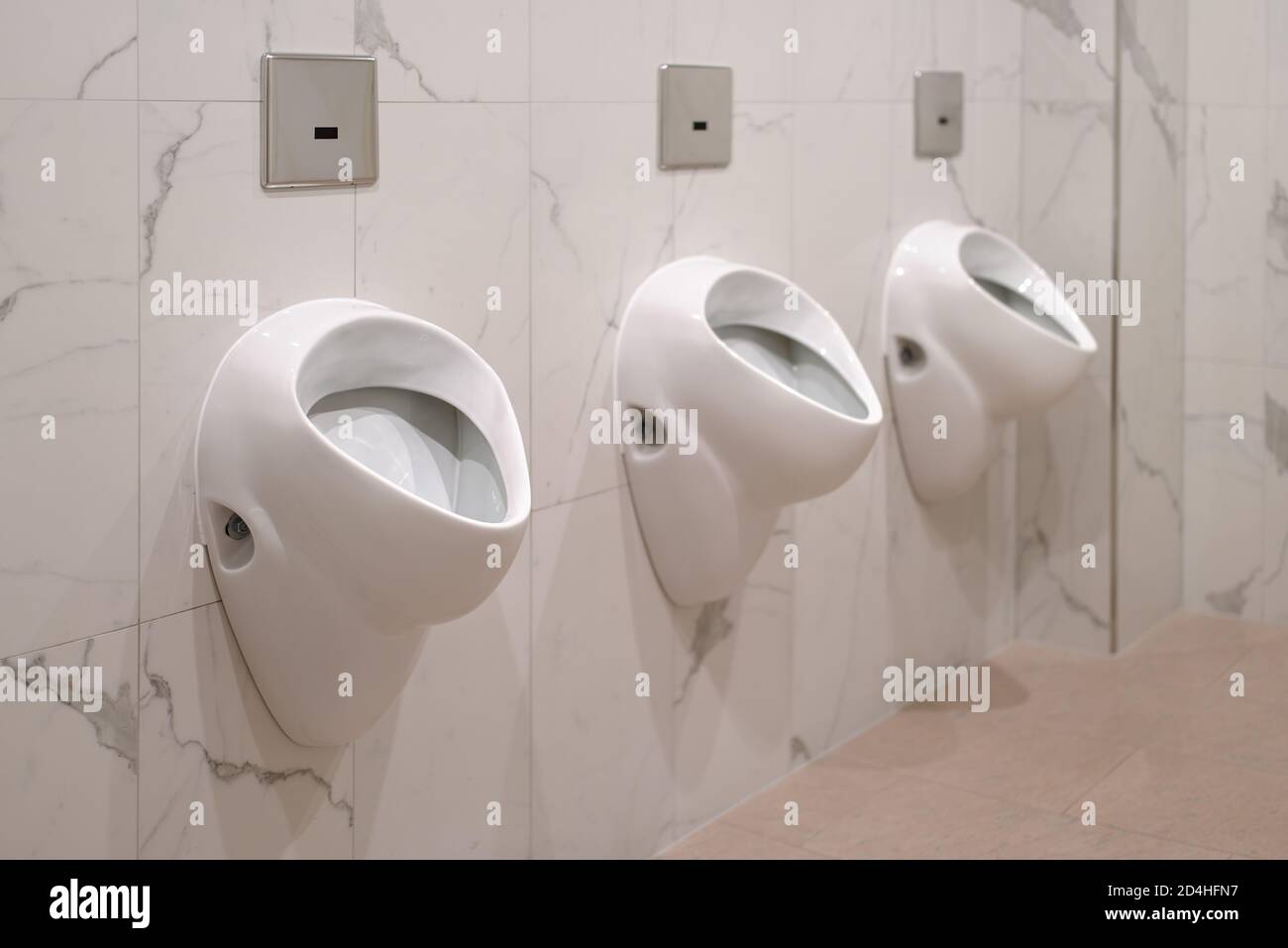 A row of three ceramic urinals Stock Photo - Alamy