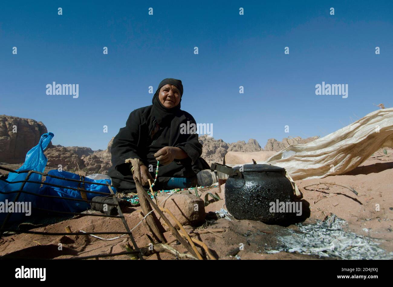 Jordanian Bedouin woman making tea on an open fire in Petra, Jordan ...
