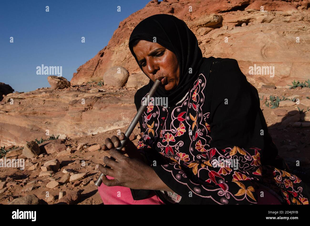 A Jordanian Bedouin woman plays music on a pipe in Petra, Jordan.Petra ...