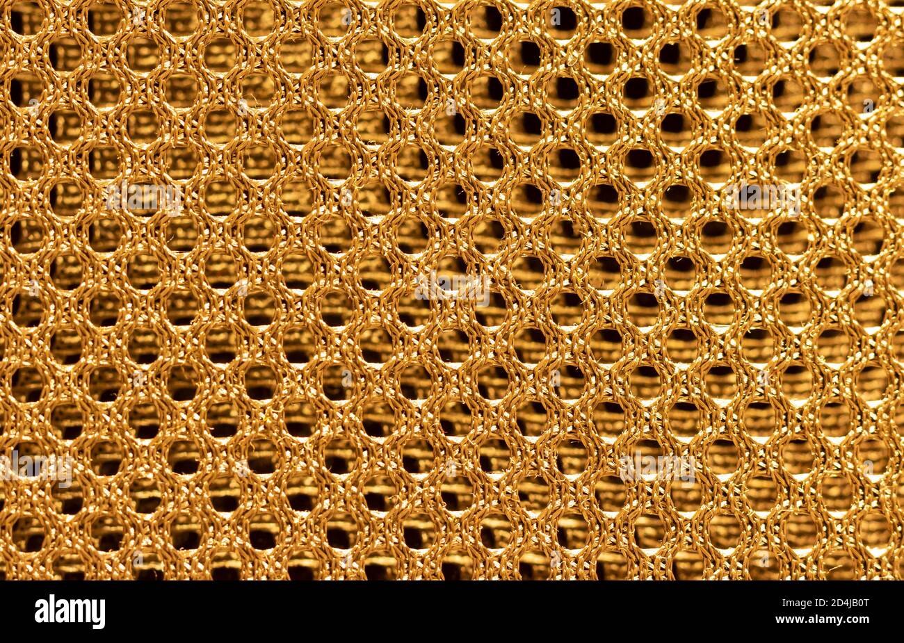 Gold double shiny braided metal mesh with a black background behind ...