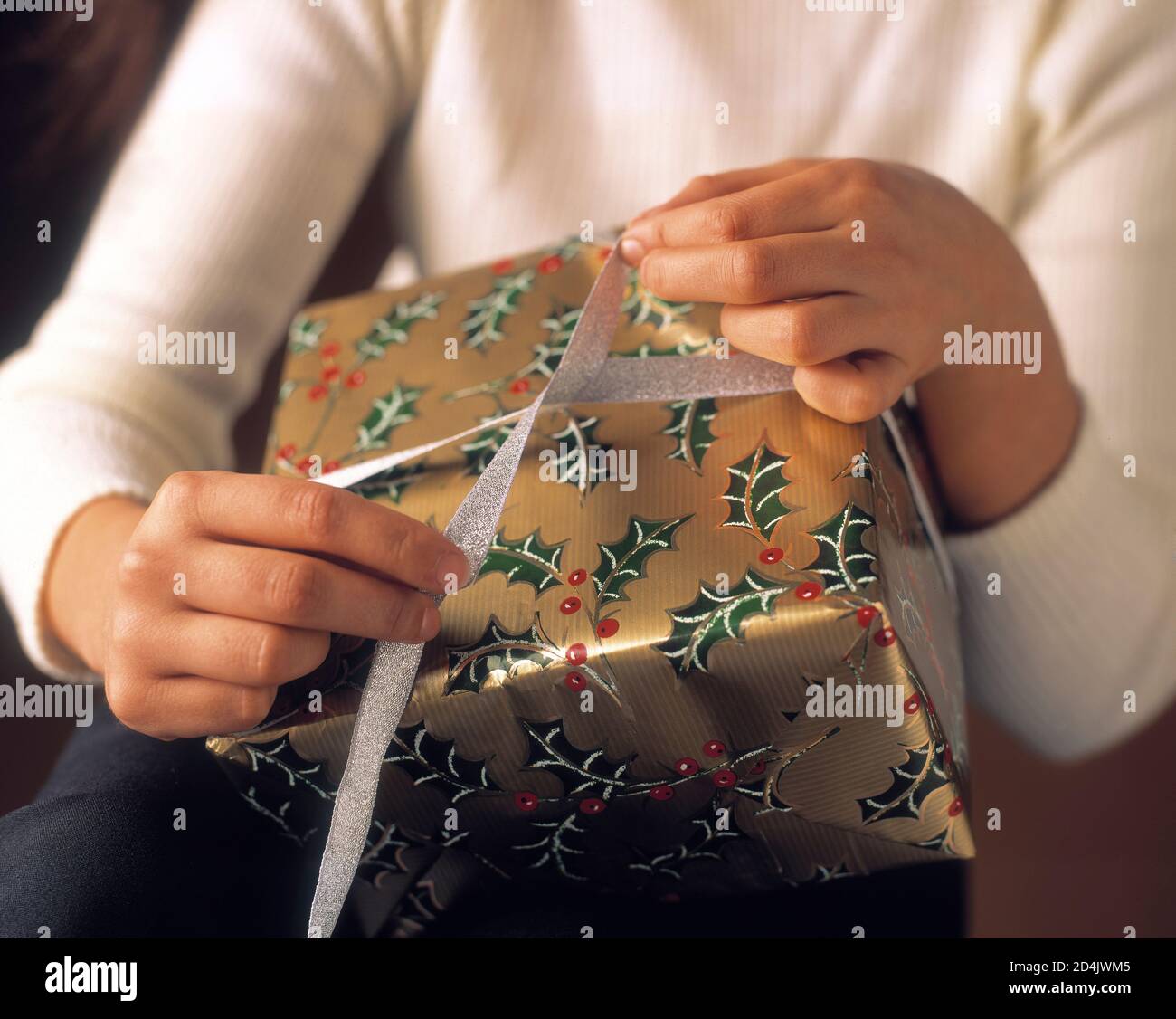 Woman unwrapping Christmas present Stock Photo - Alamy