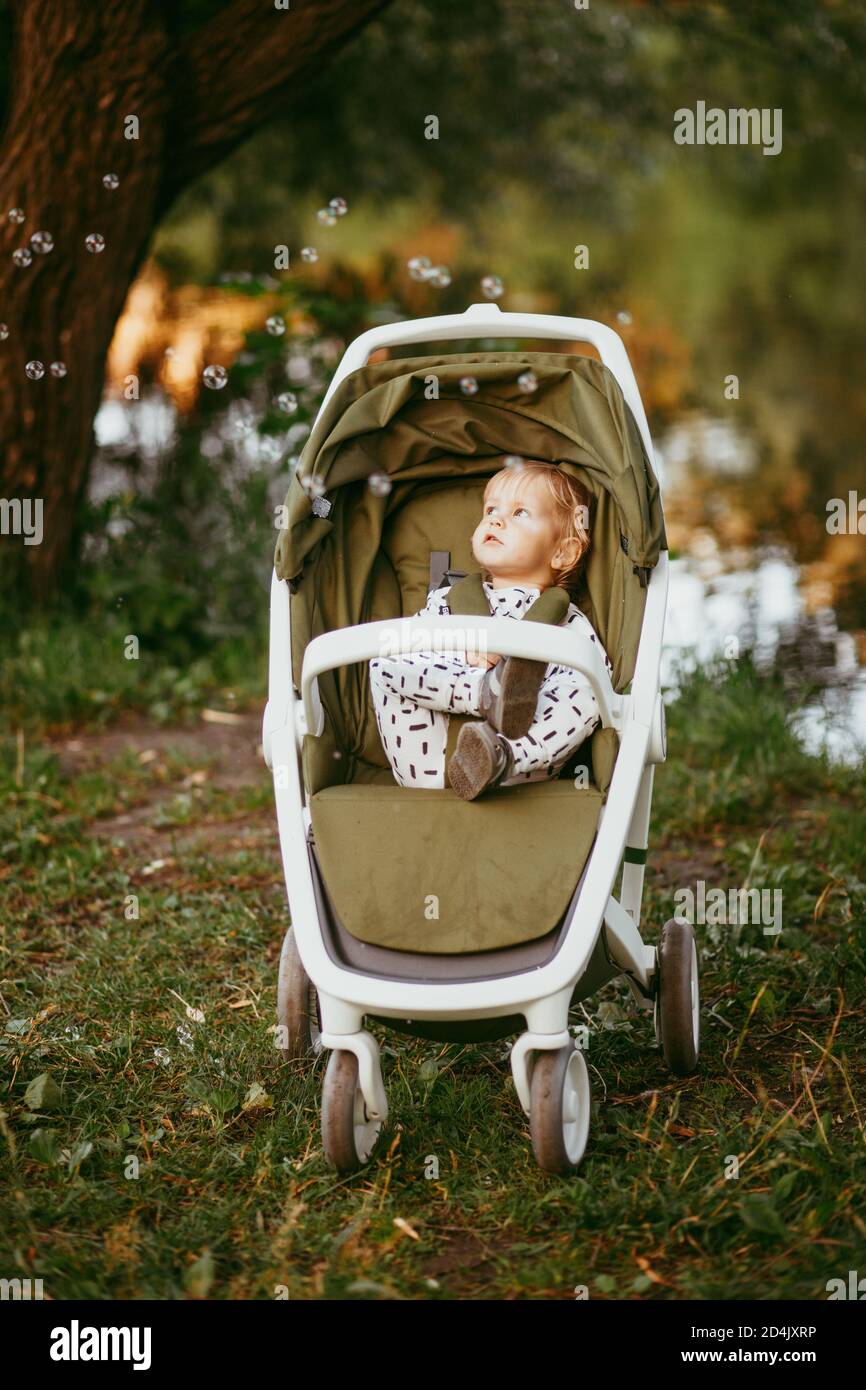 Cute healthy little boy sitting in a stroller and waiting for his ...