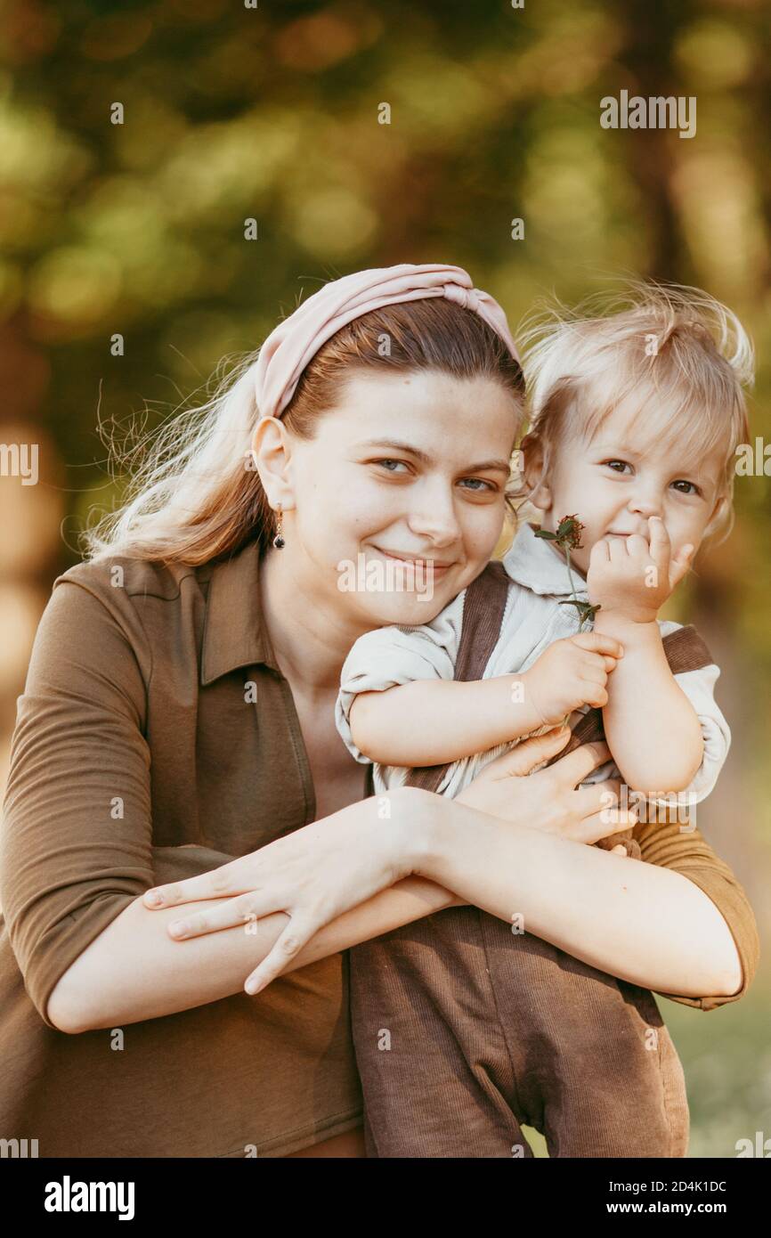 A young mother helps her son start walking. A mother teaches her son ... A young mother helps her son start walking. A mother teaches her son ...