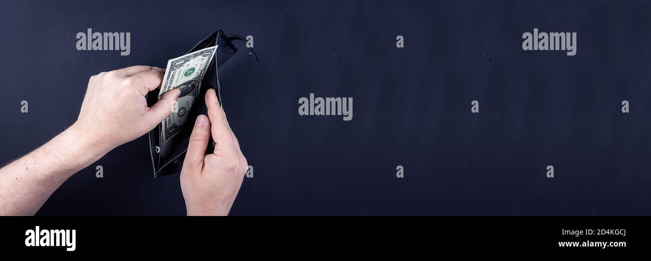 A man is holding an open wallet with money in his hands. Hands take out ...