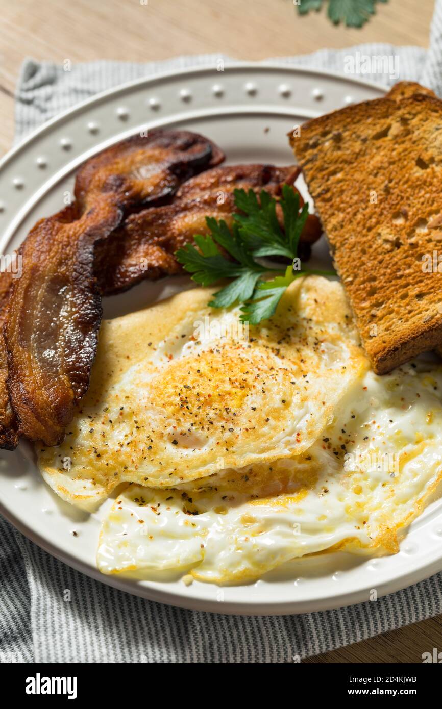 Homemade Over Easy Eggs with Bacon and Toast Stock Photo - Alamy